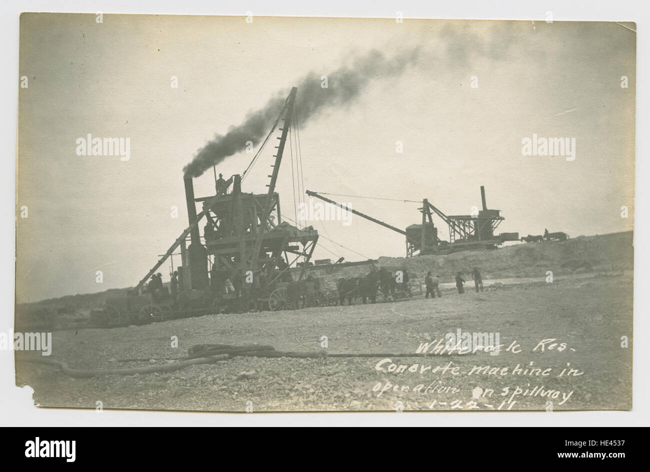 A historic image of a concrete machine in operation on the spillway of ...