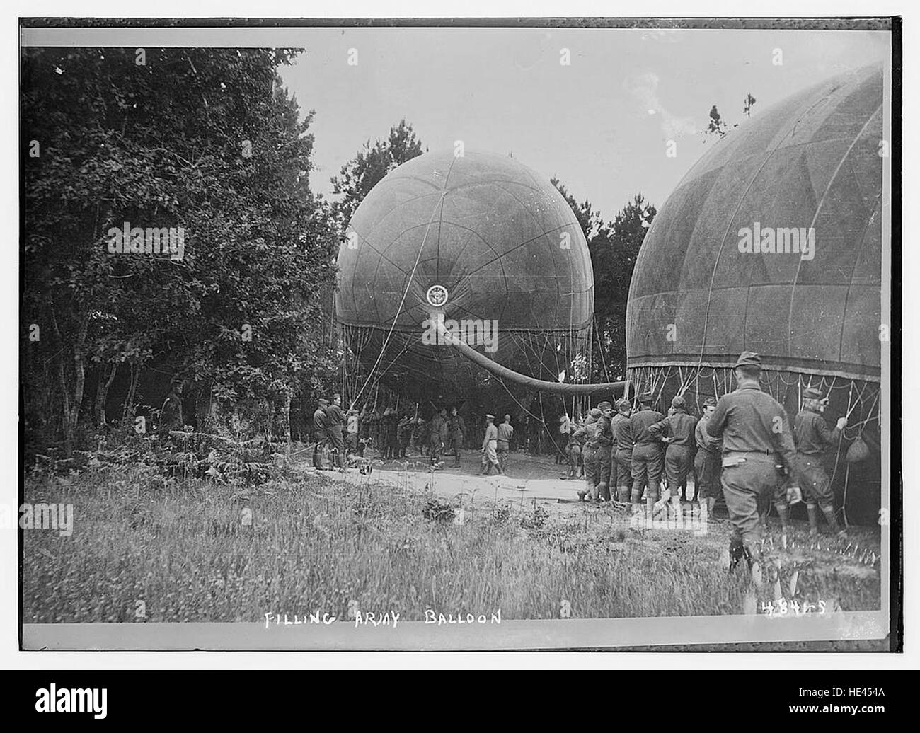 This image captures a historic scene of an army balloon being filled ...