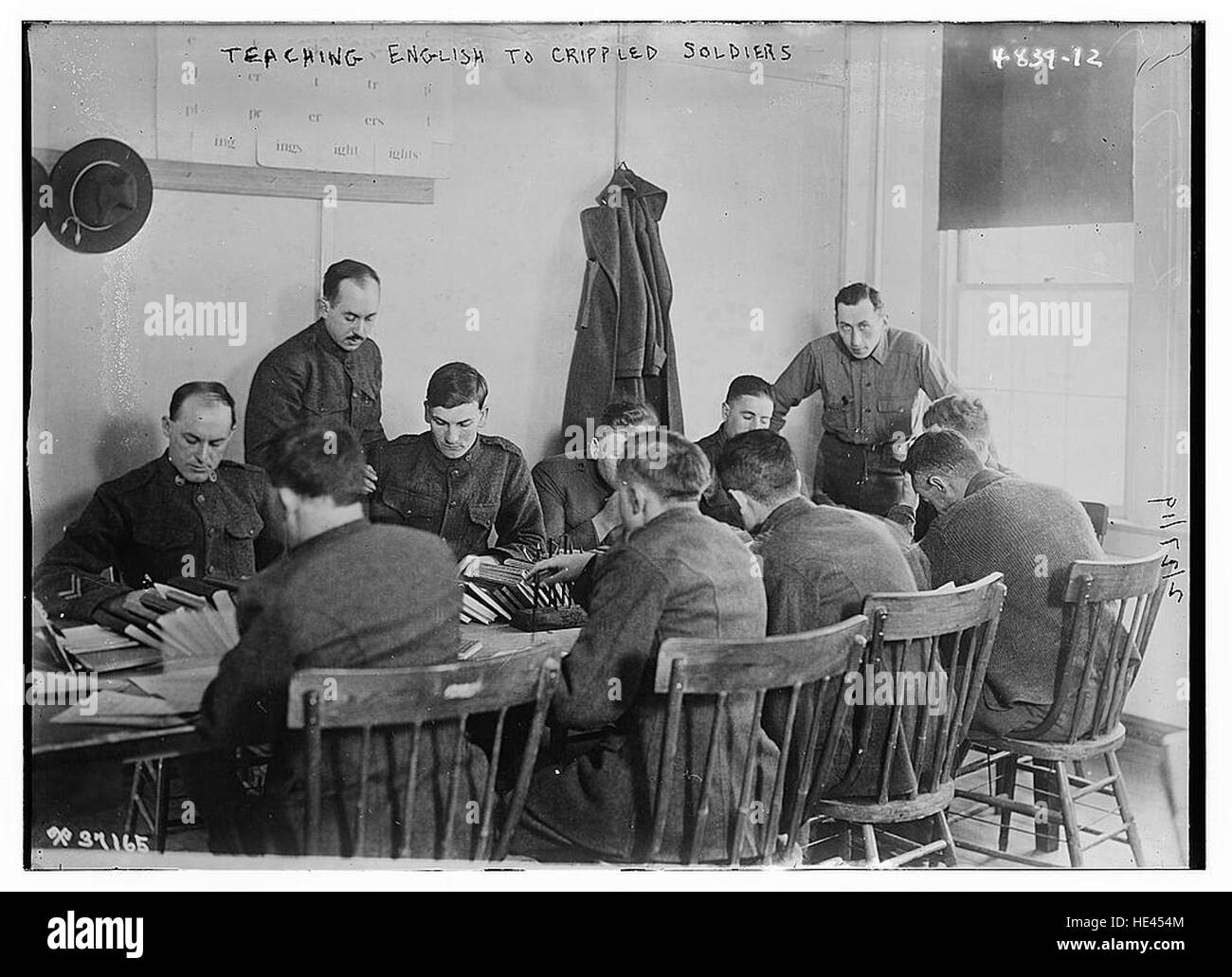 This historical image shows a teacher instructing soldiers who have ...
