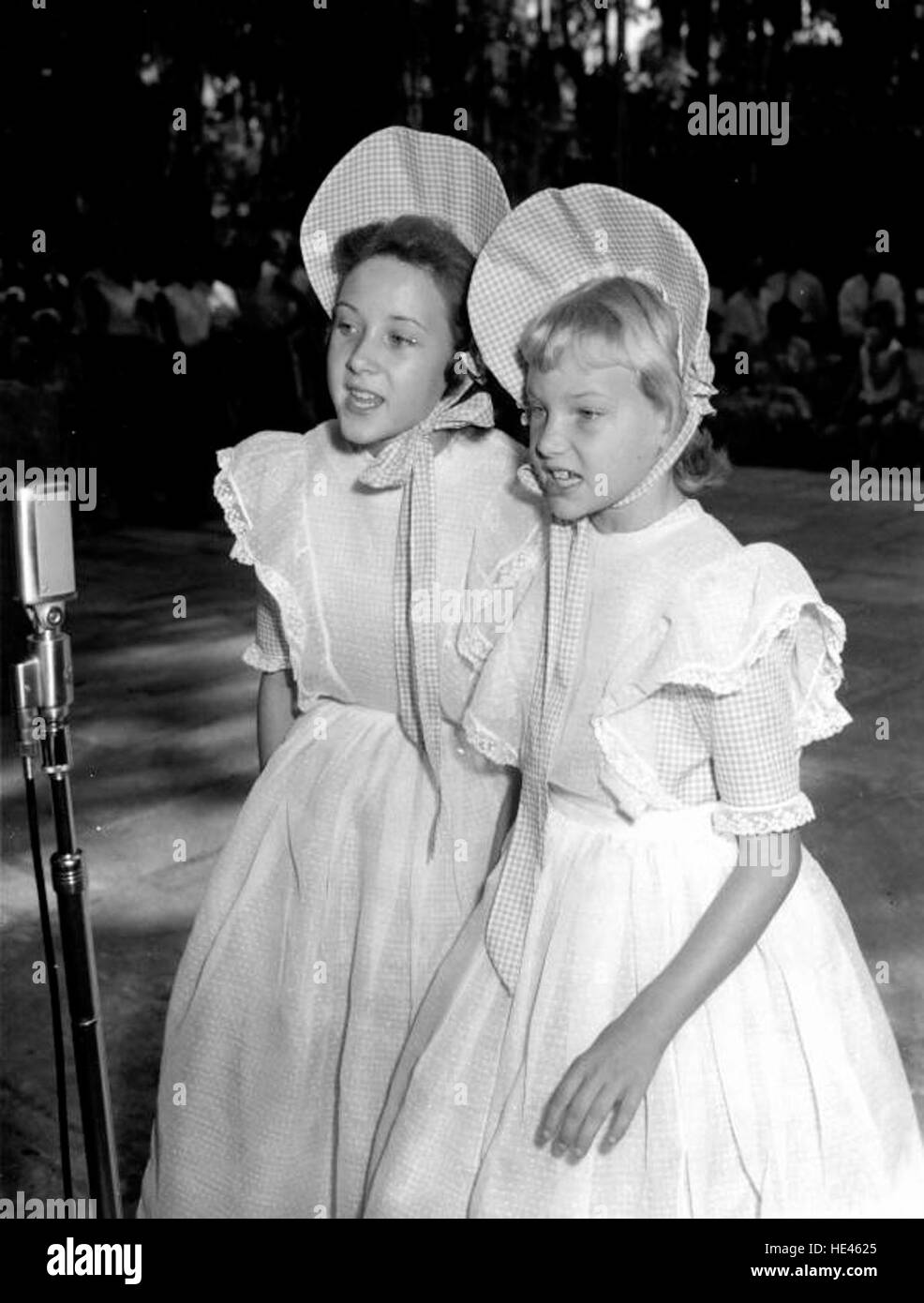 This historical image captures two sisters performing at a Folk ...