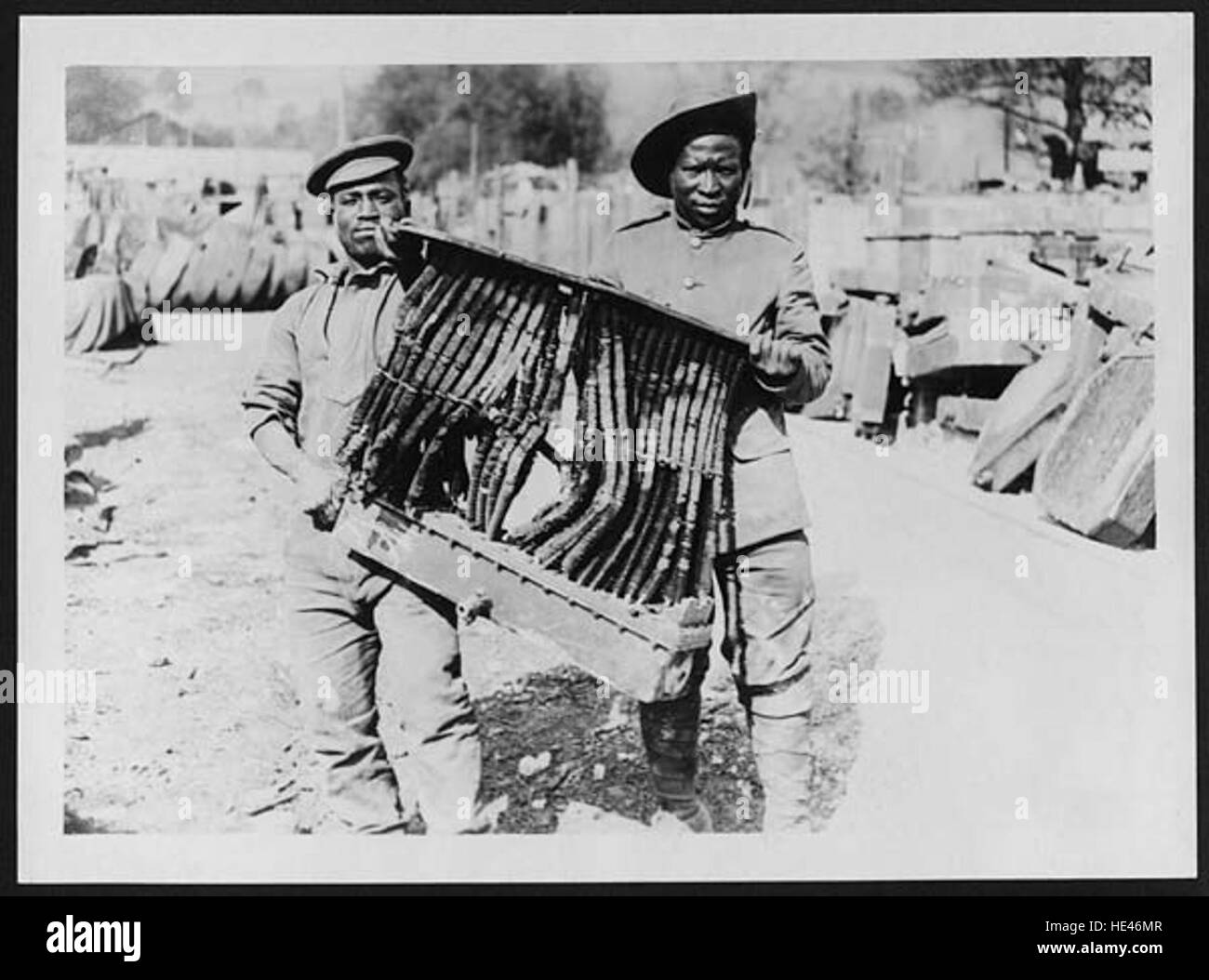 This image shows native laborers holding a damaged radiator, a relic ...