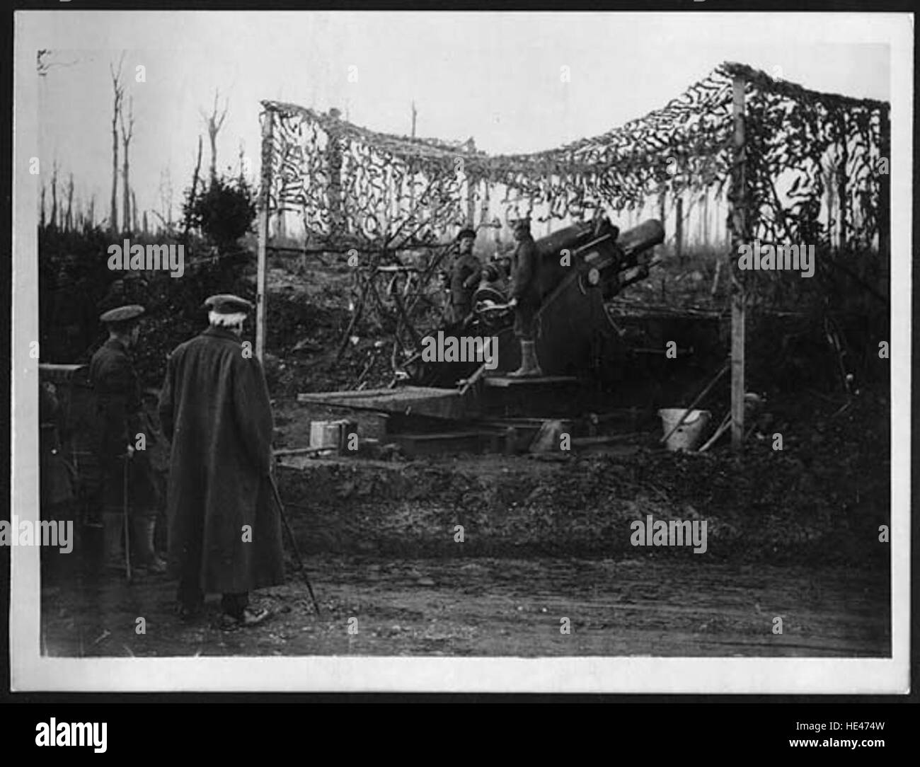 A historical photograph of Mr. Balfour observing a large military gun ...