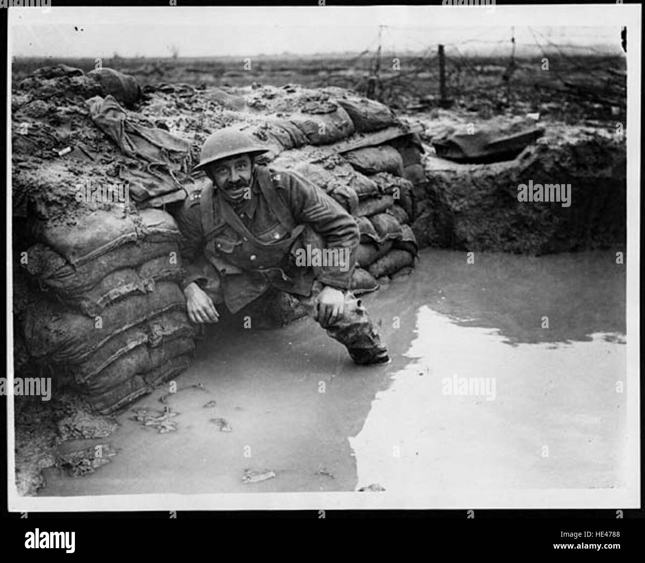 A historical photograph shows a flooded dug-out in a front-line trench ...
