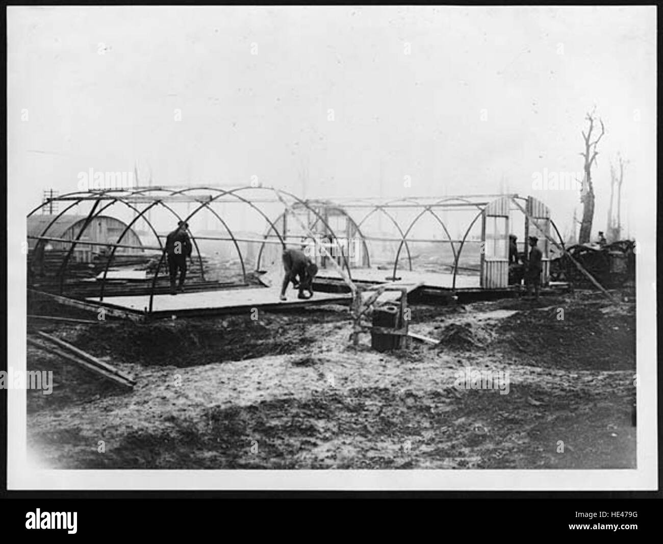 The image shows soldiers constructing a new type of hut designed for ...