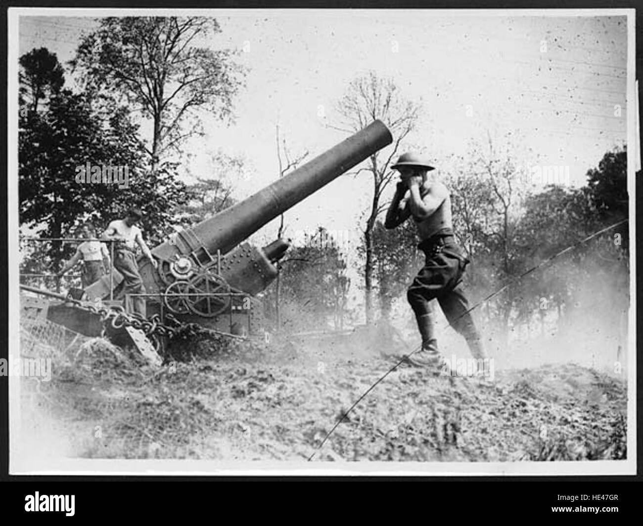 This vintage photograph captures the dramatic moment of a large cannon ...