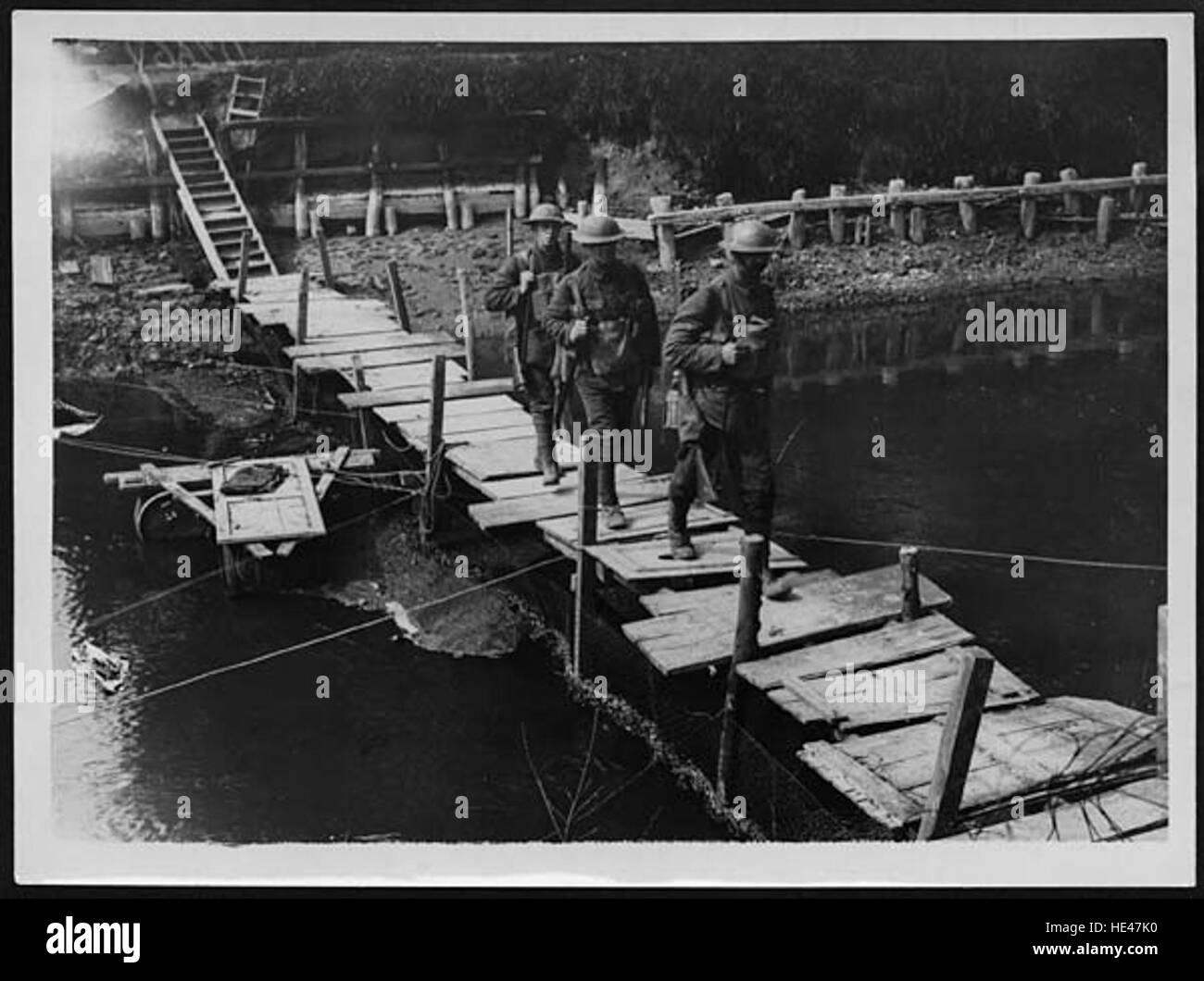 This historical photograph depicts a temporary bridge constructed ...