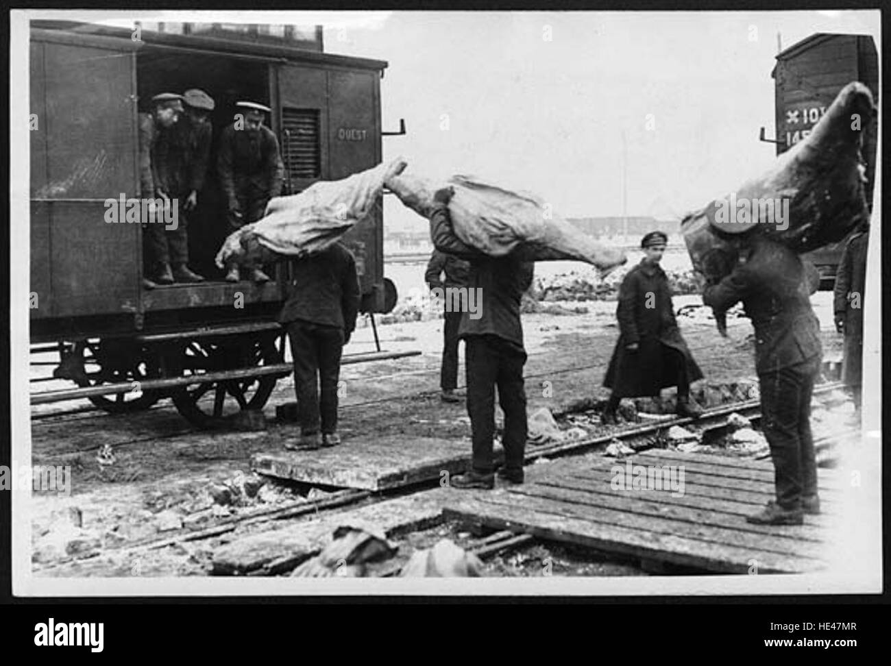 This historical image captures the process of loading meat into a train ...
