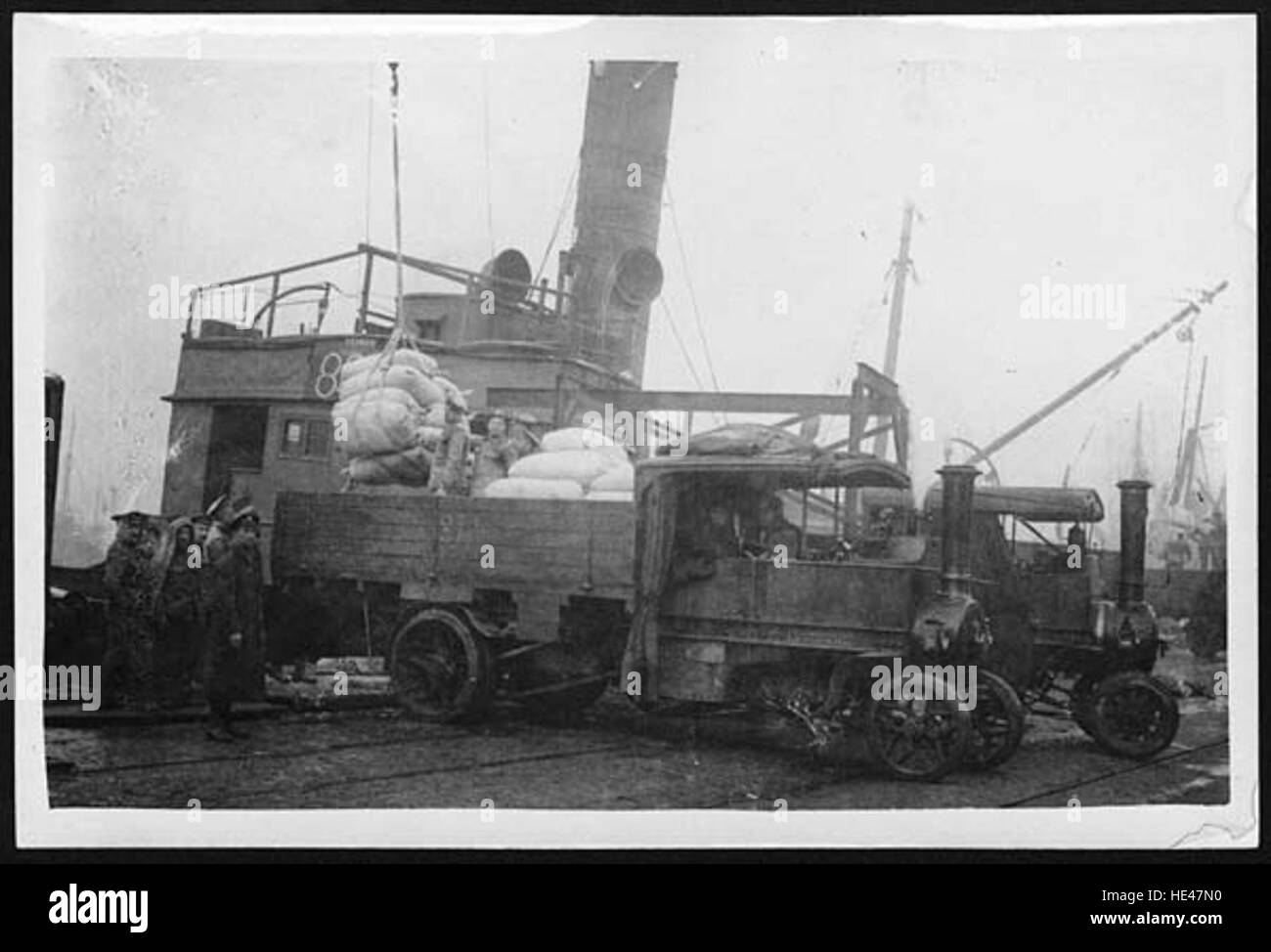 This historical image captures the process of unloading flour from a ...