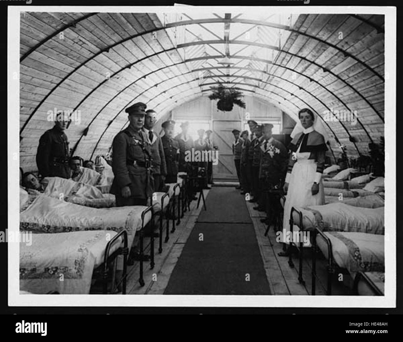 This historic image depicts a Nissen hut transformed into a hospital ...