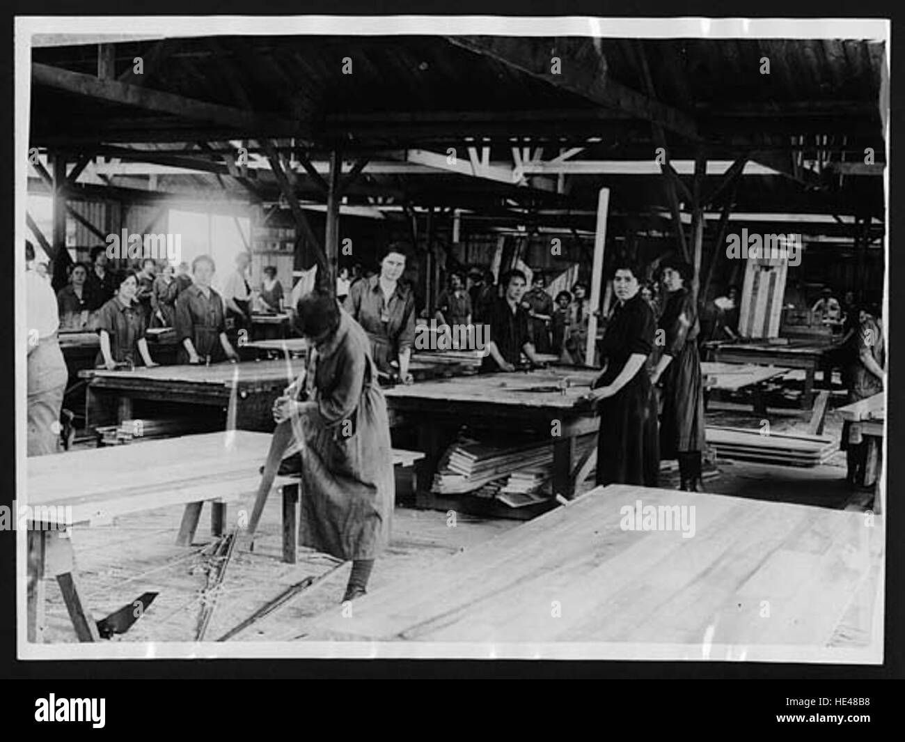 This historical image depicts a lady carpenter working in a workshop ...