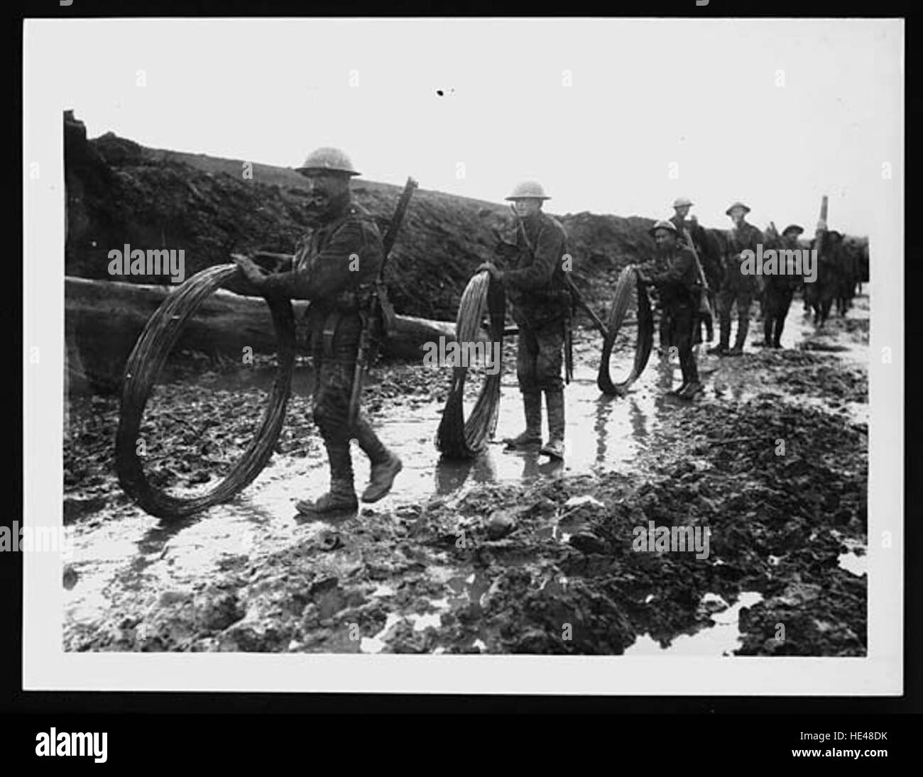 This historical image depicts soldiers involved in wiring parties ...
