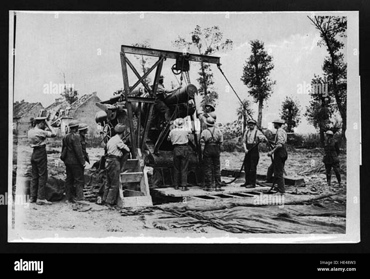 A historical wartime photograph depicting a heavy howitzer in action ...