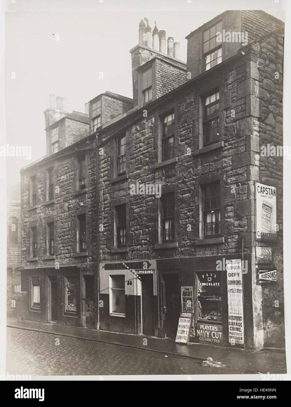 This image depicts a historic two-storey building, with shops located ...