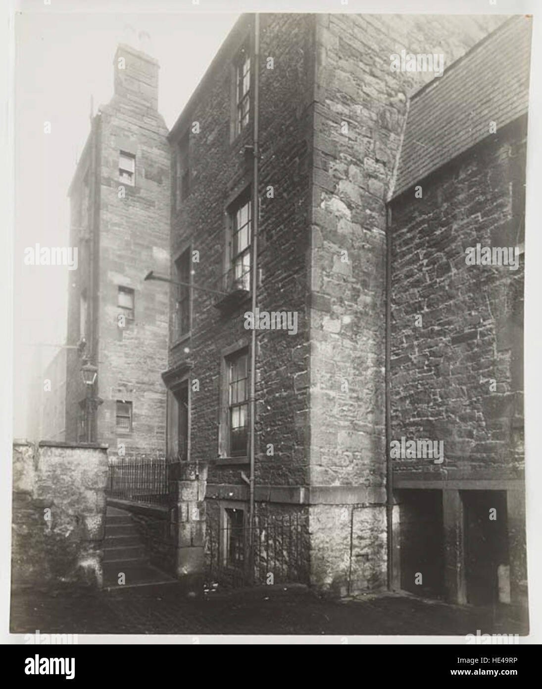 The image showcases a historic cobbled court area with a three-story ...