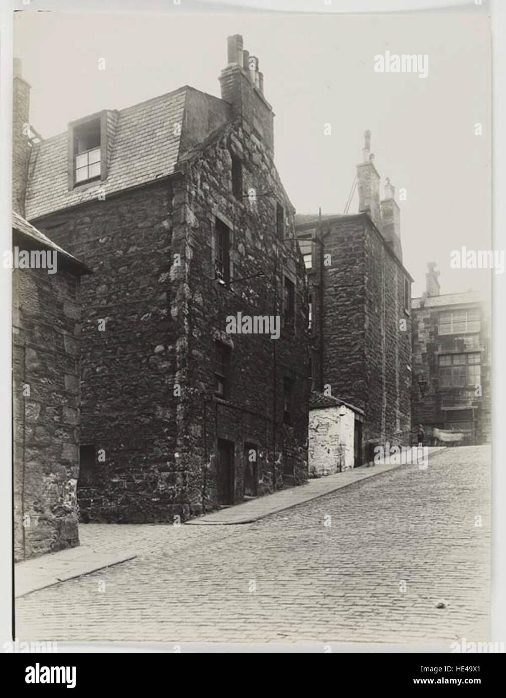 This historic image showcases a row of three-story tenement buildings ...