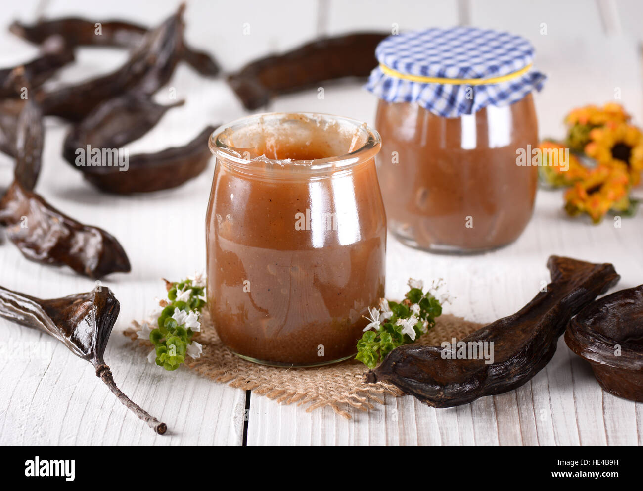 carob jam in glass jar with fruit around Stock Photo - Alamy
