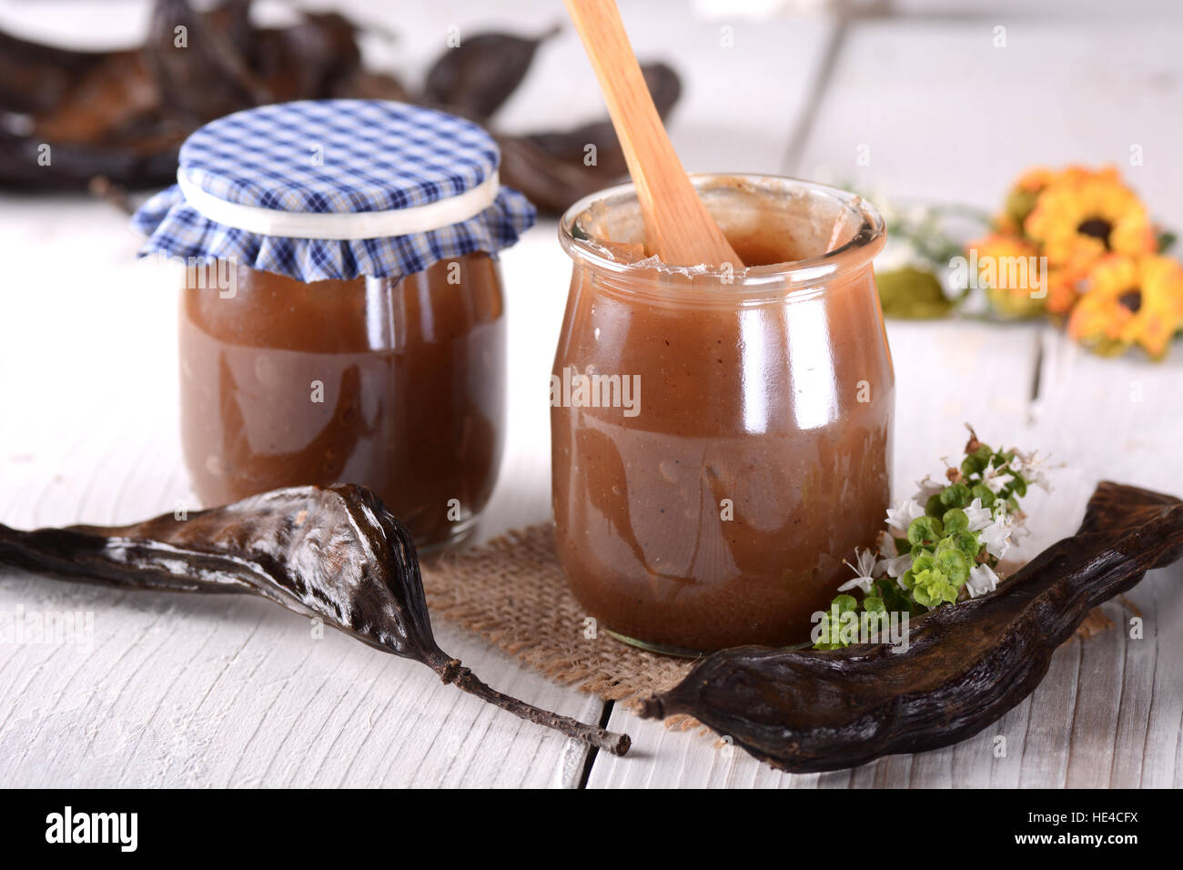 carob jam in glass jar with fruit around Stock Photo - Alamy