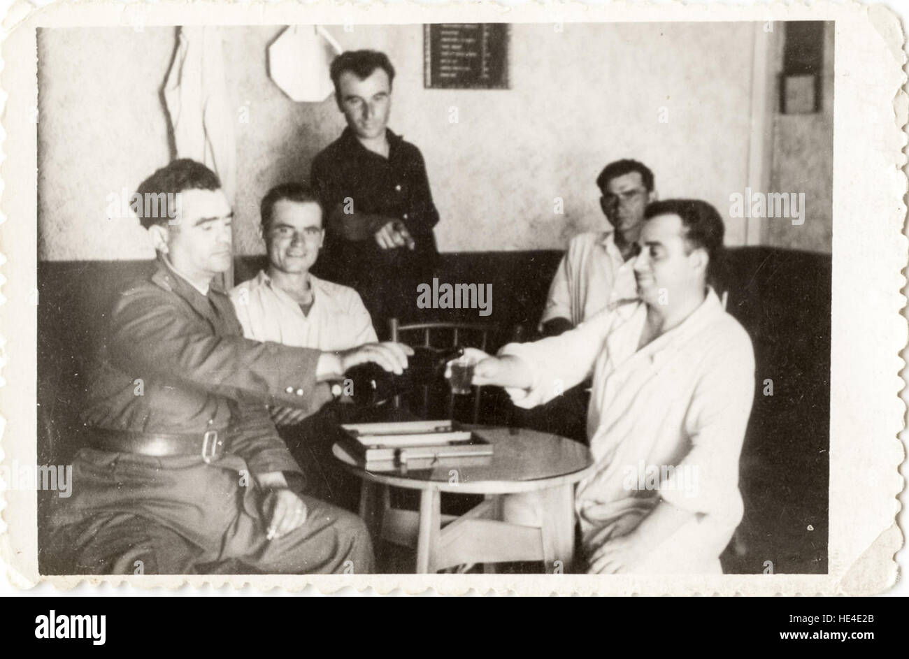 A photograph of Ion Lupașneanu with friends at a table with a glass of ...