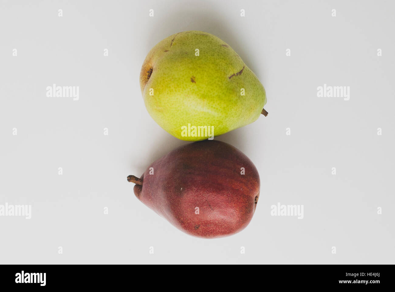 Purple and green pears on a white background Stock Photo - Alamy