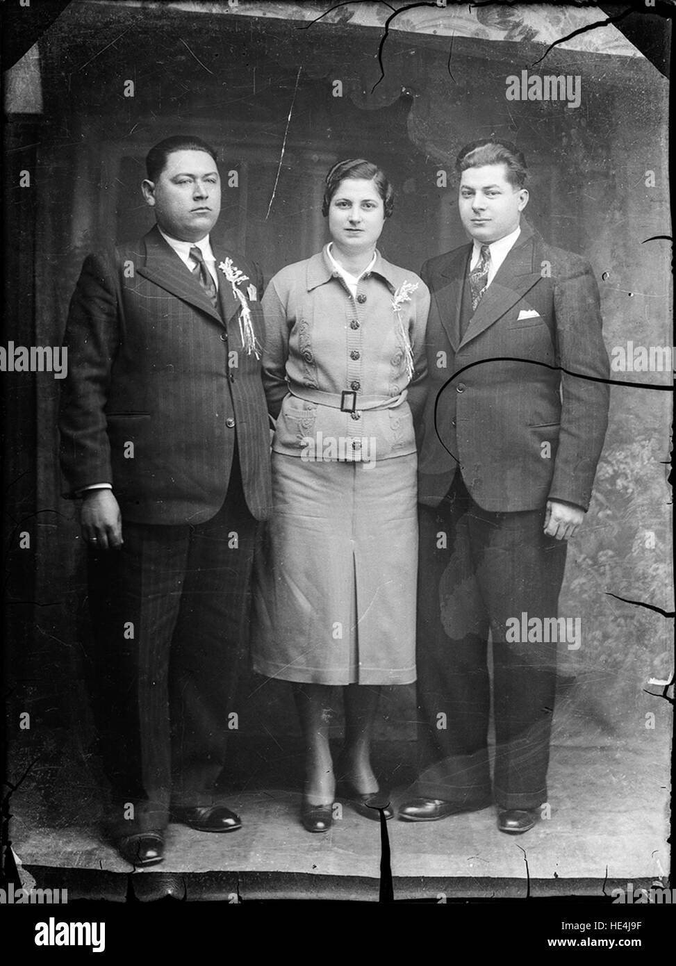 A woman standing between two men in a historic photograph, captured in ...
