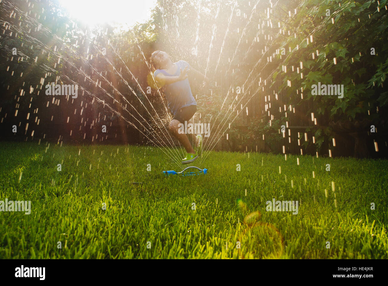 Children playing in sprinkler hi-res stock photography and images - Alamy