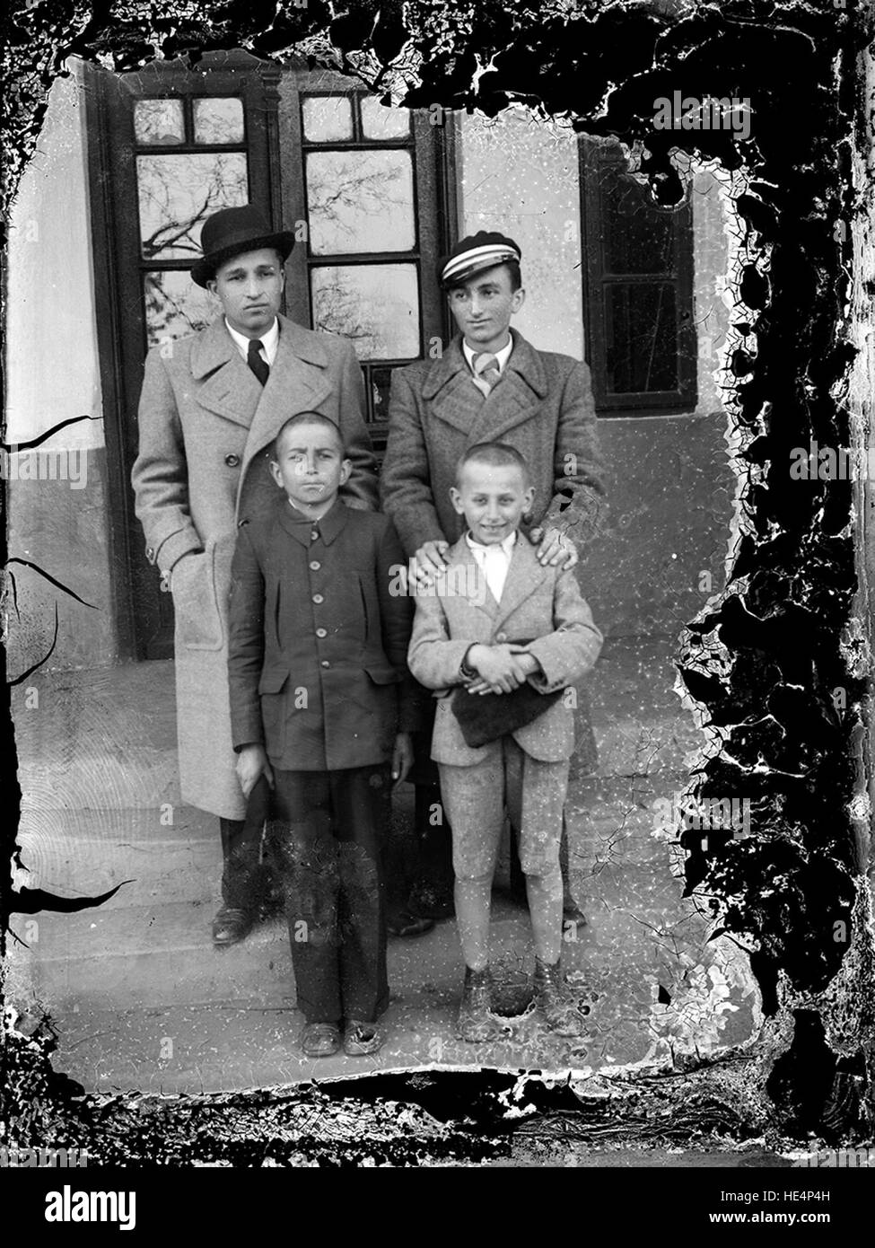 A vintage photograph of four boys from Ialomita, Romania, offering a ...