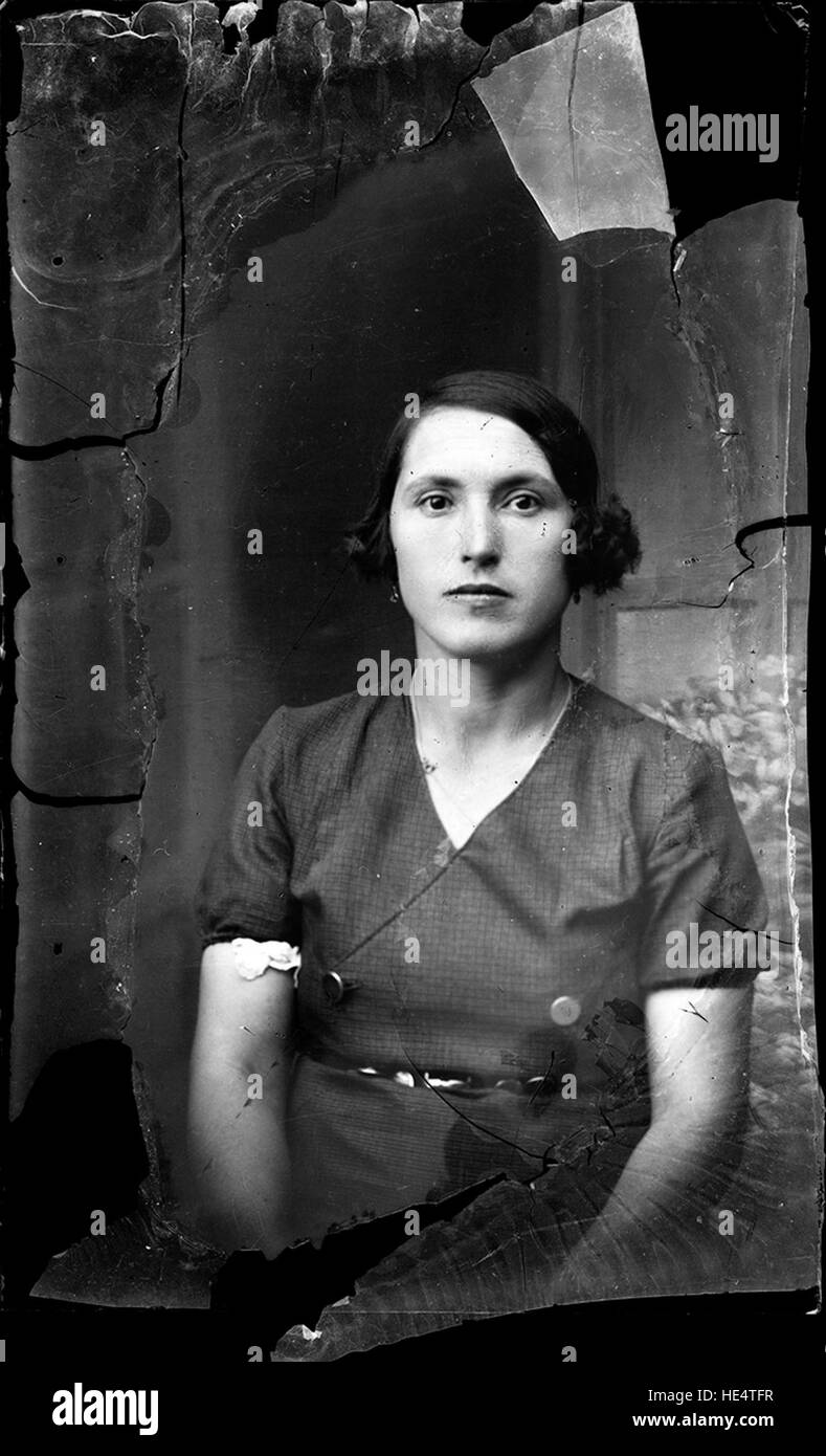 This black-and-white photograph captures a woman in traditional ...