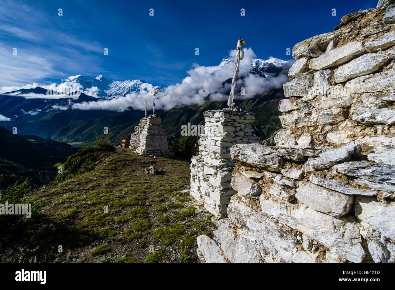 White chorten on a hill above Manang, the Annapurna Range in the ...
