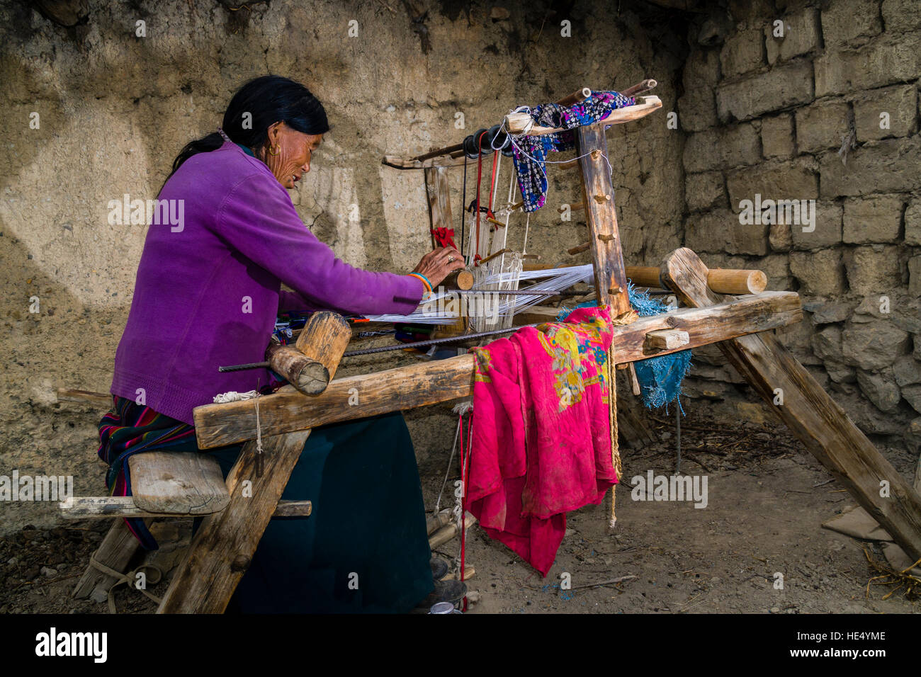 A local woman is weaving material at a loom in open air Stock Photo - Alamy