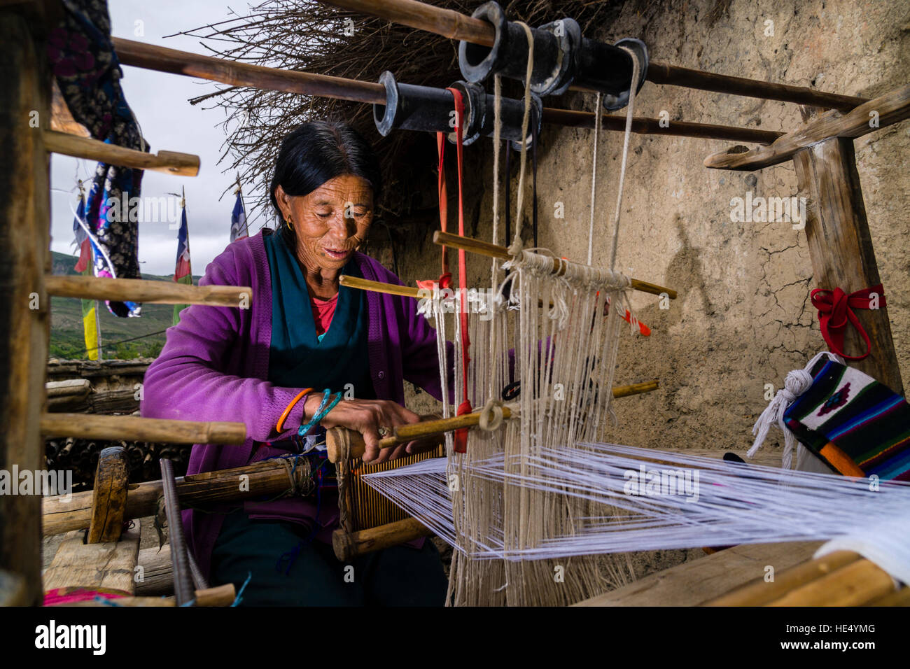 A local woman is weaving material at a loom in open air Stock Photo - Alamy