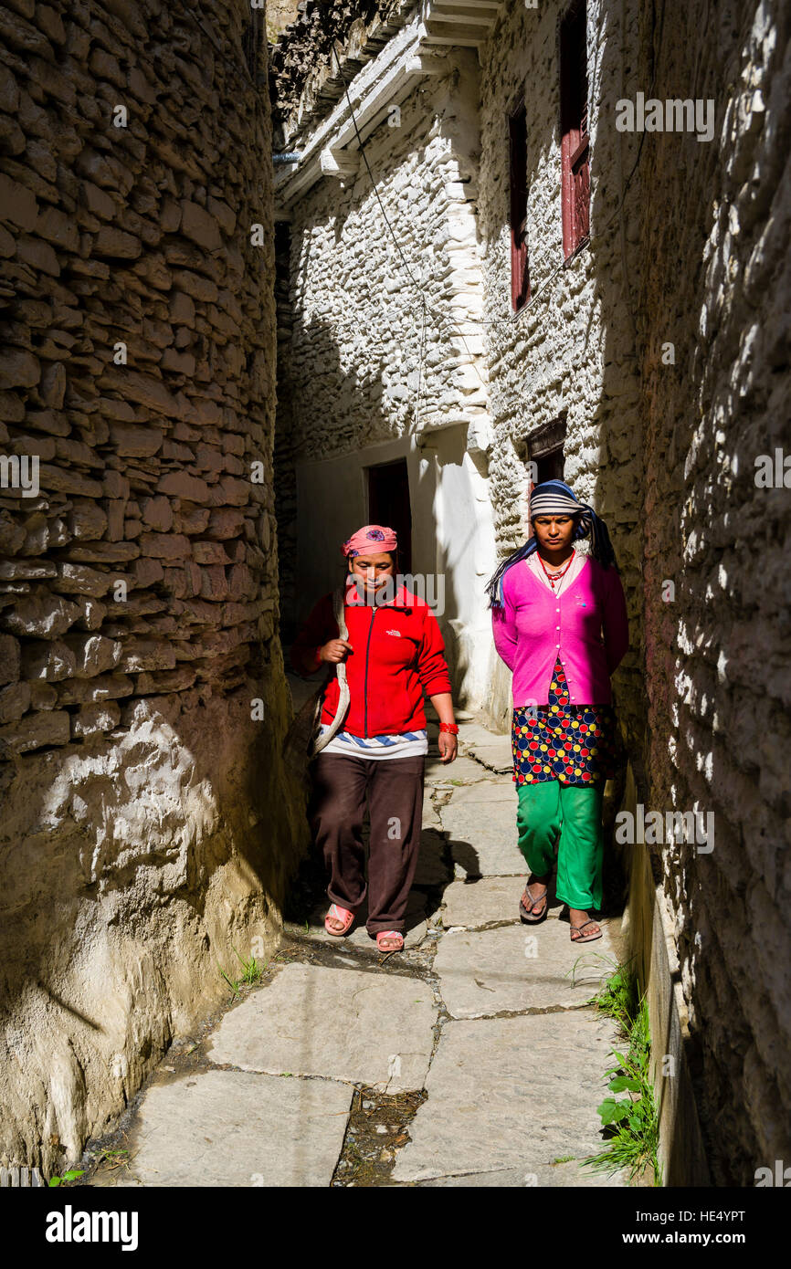 A small alleyway between the houses of the the village, two local women ...
