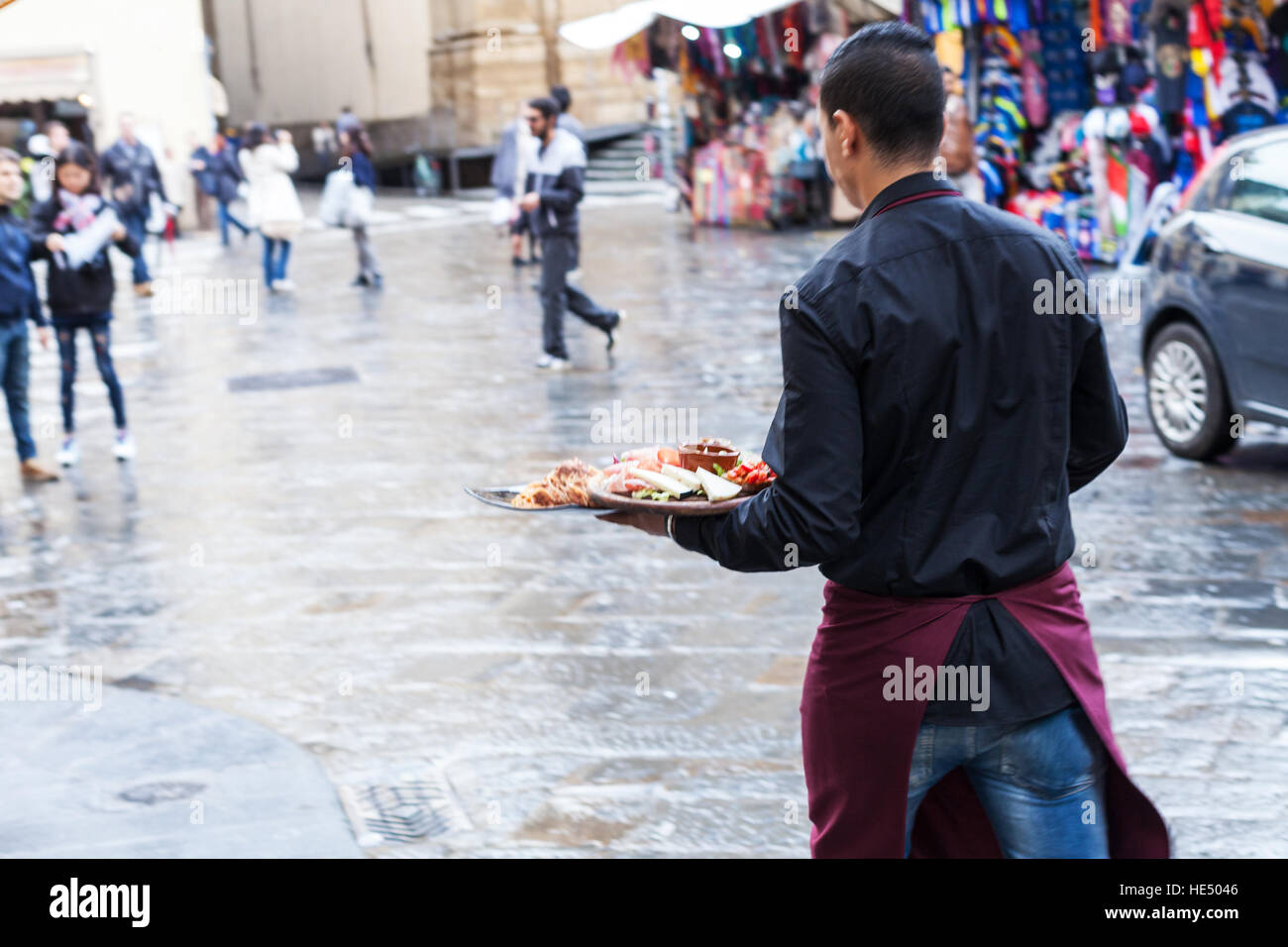 FLORENCE, ITALY - NOVEMBER 6, 2016: waiter with plates in outdoor ...