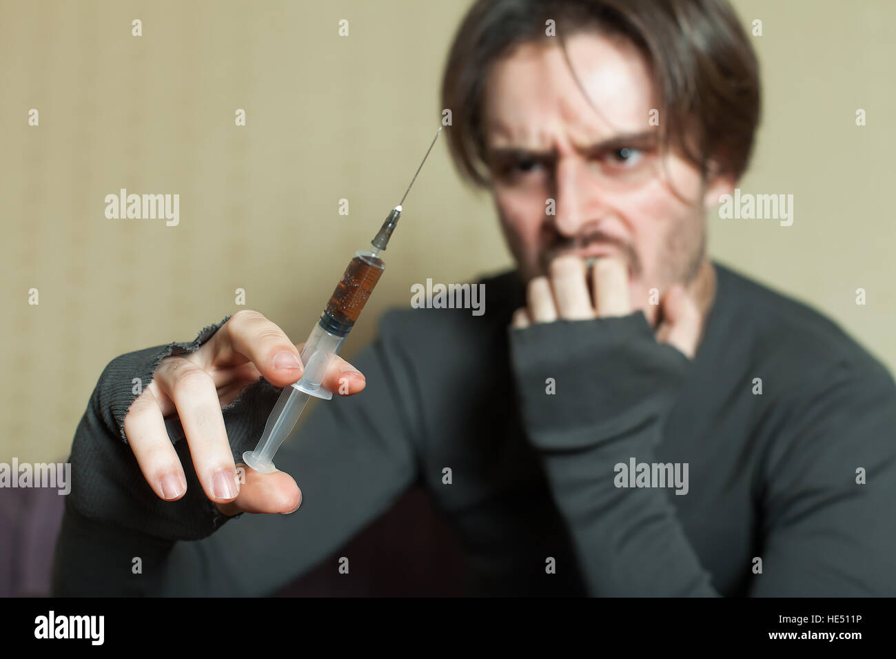 Abuse addict man with syringe in hand Stock Photo - Alamy