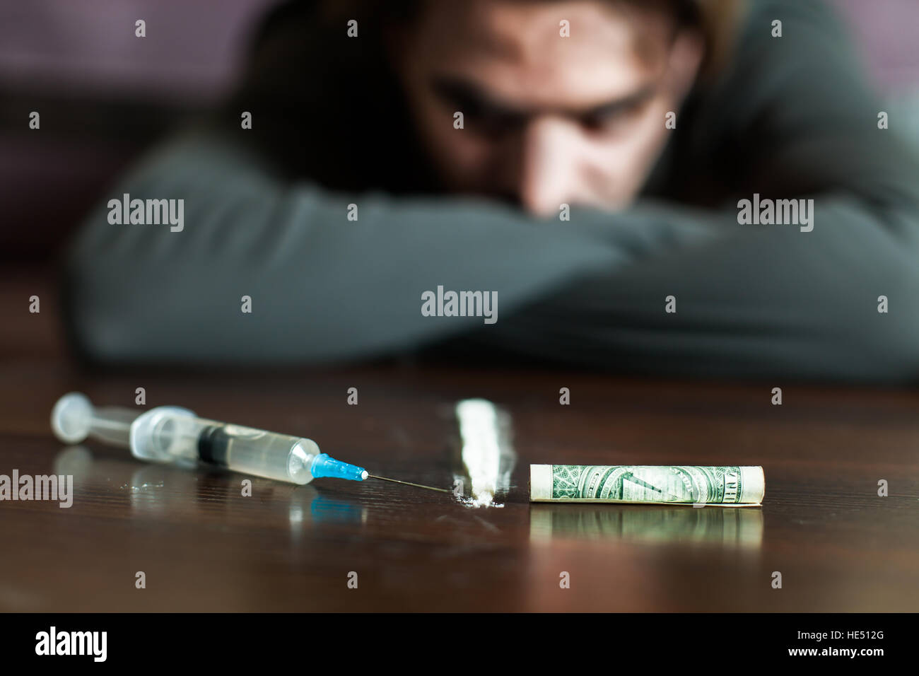 Addiction man look at the table with narcotics Stock Photo - Alamy