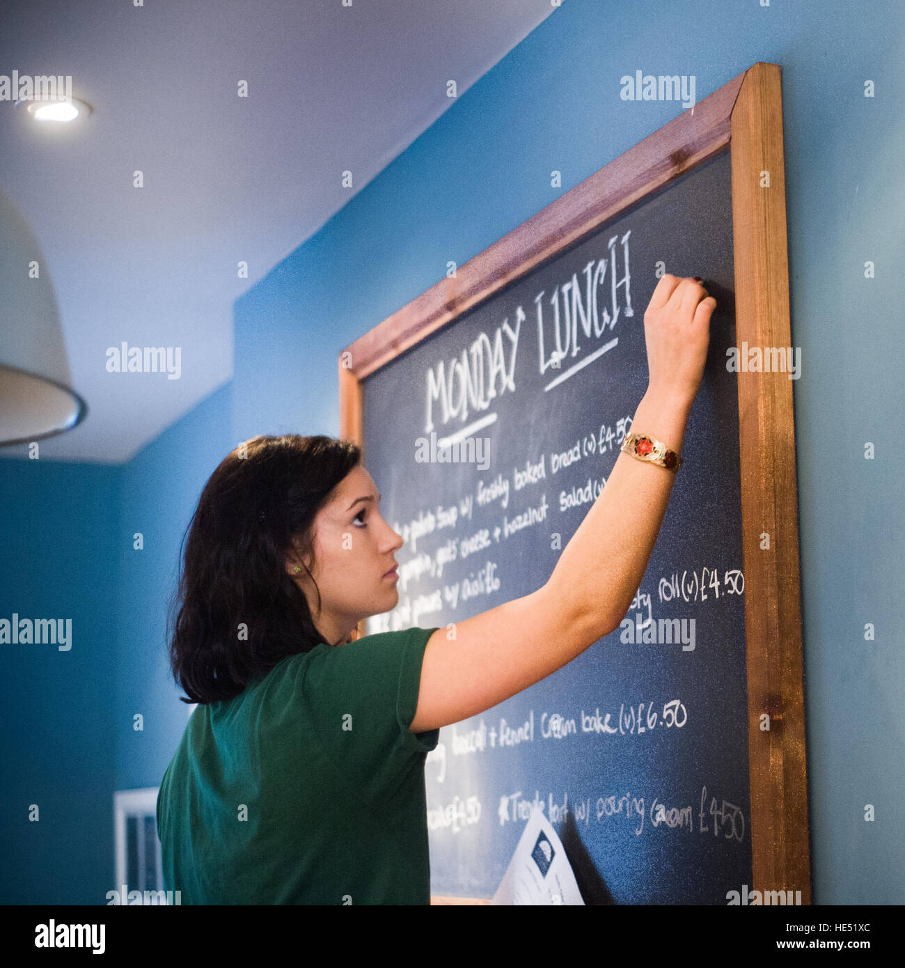 Waitress writing lunch menu on the blackboard in a cafe Stock Photo - Alamy