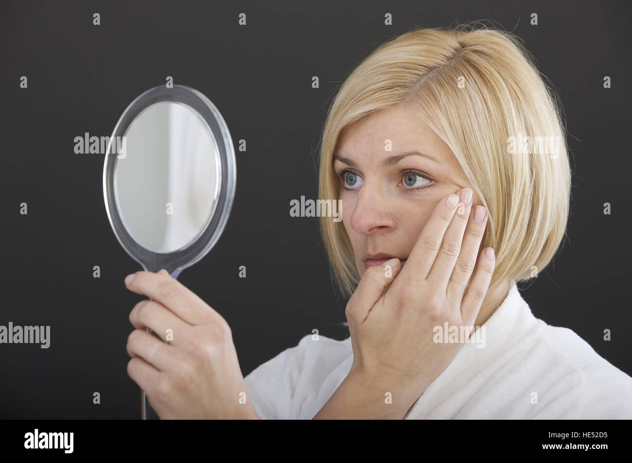 Woman looking into a mirror Stock Photo - Alamy