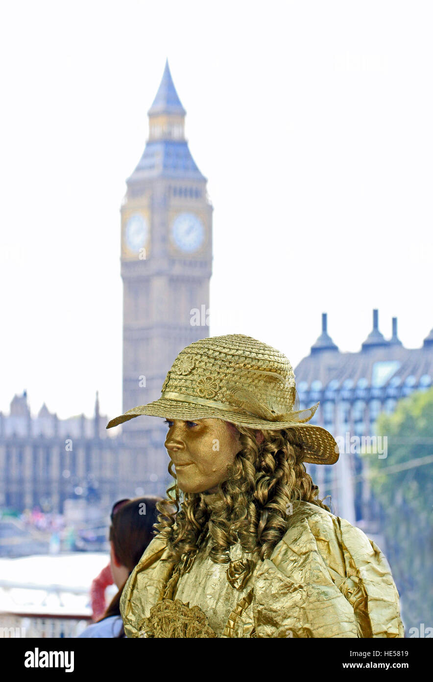 Human statue dressed in gold in front of big Ben and the houses of ...