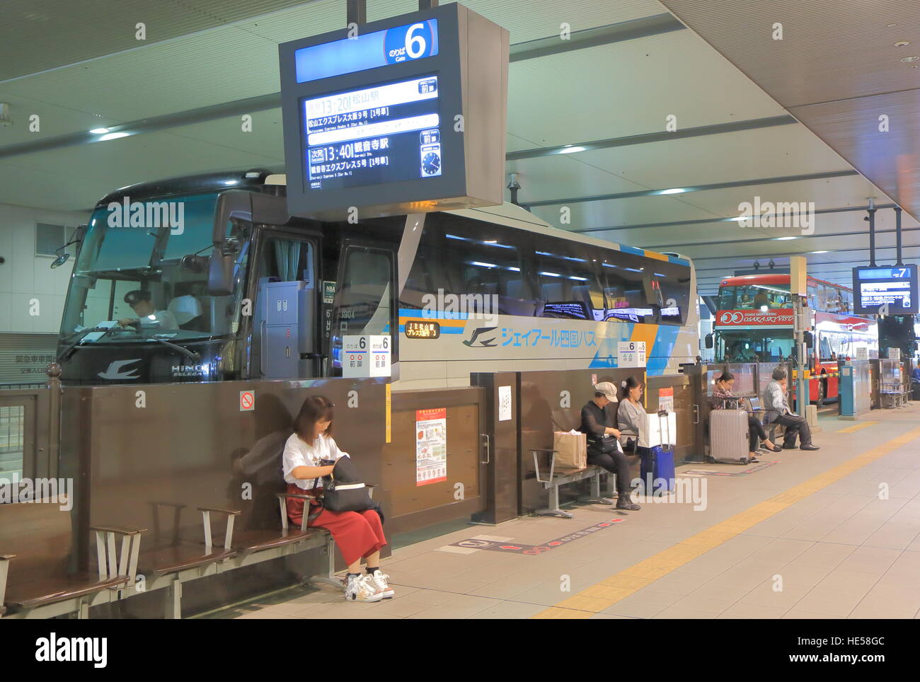People wait for long distance buses at Osaka station bus terminal in ...