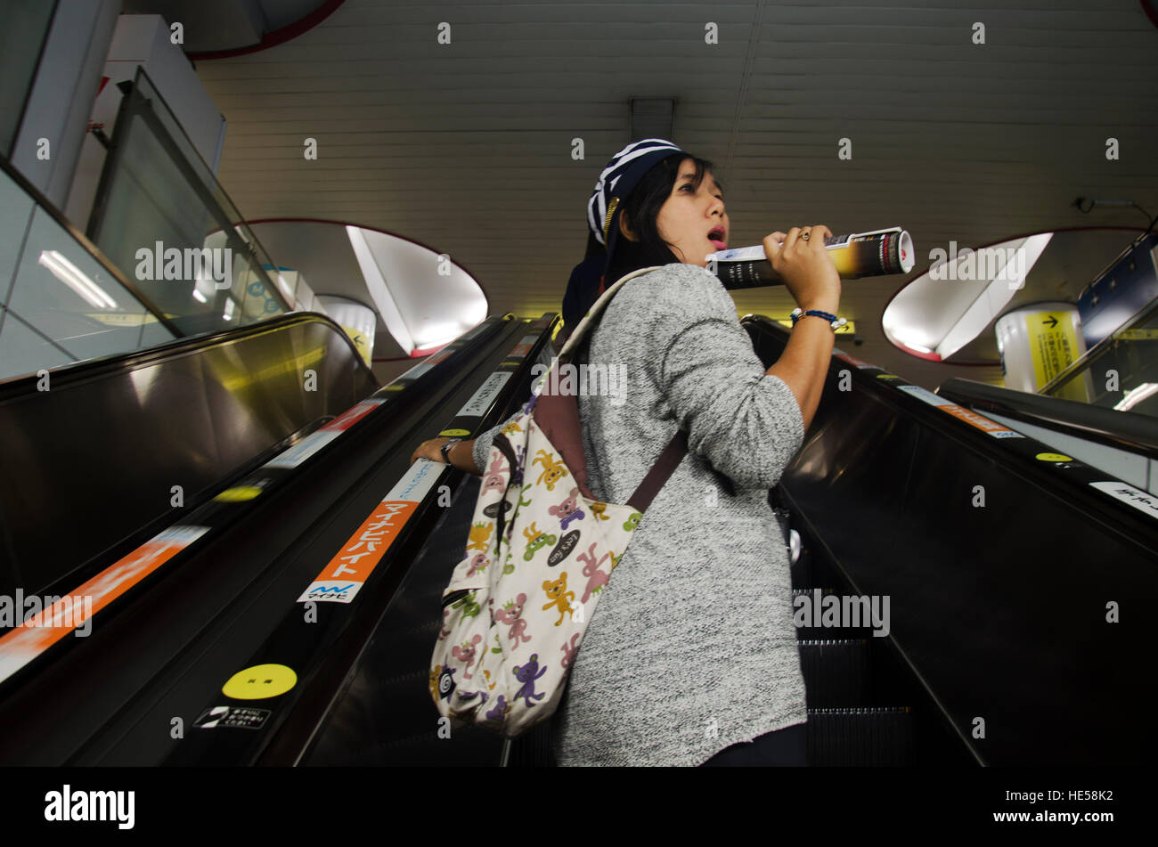 Thai women use escalator from Akabanebashi subway station up to ground ...