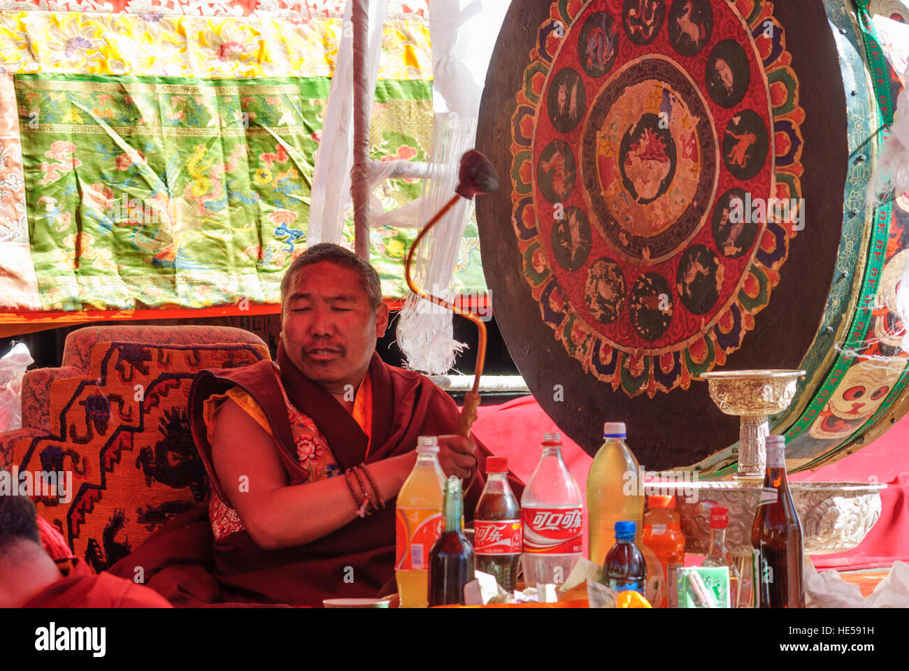 Lhasa: Monastery Sera; Drumming monk in front of a Thangka (scroll) at ...