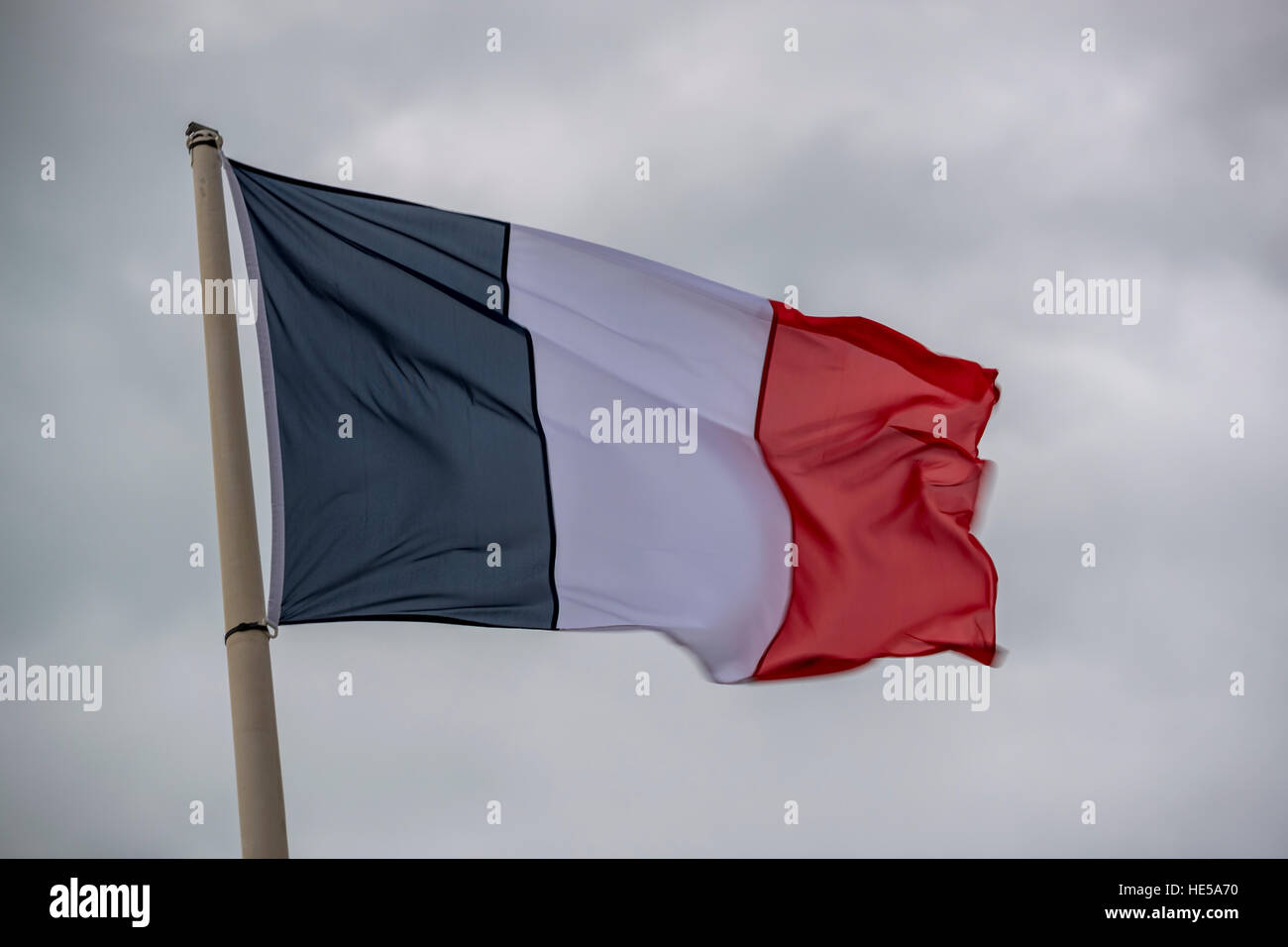 French flag flying in a strong wind on the coast at Dunkirk, France ...