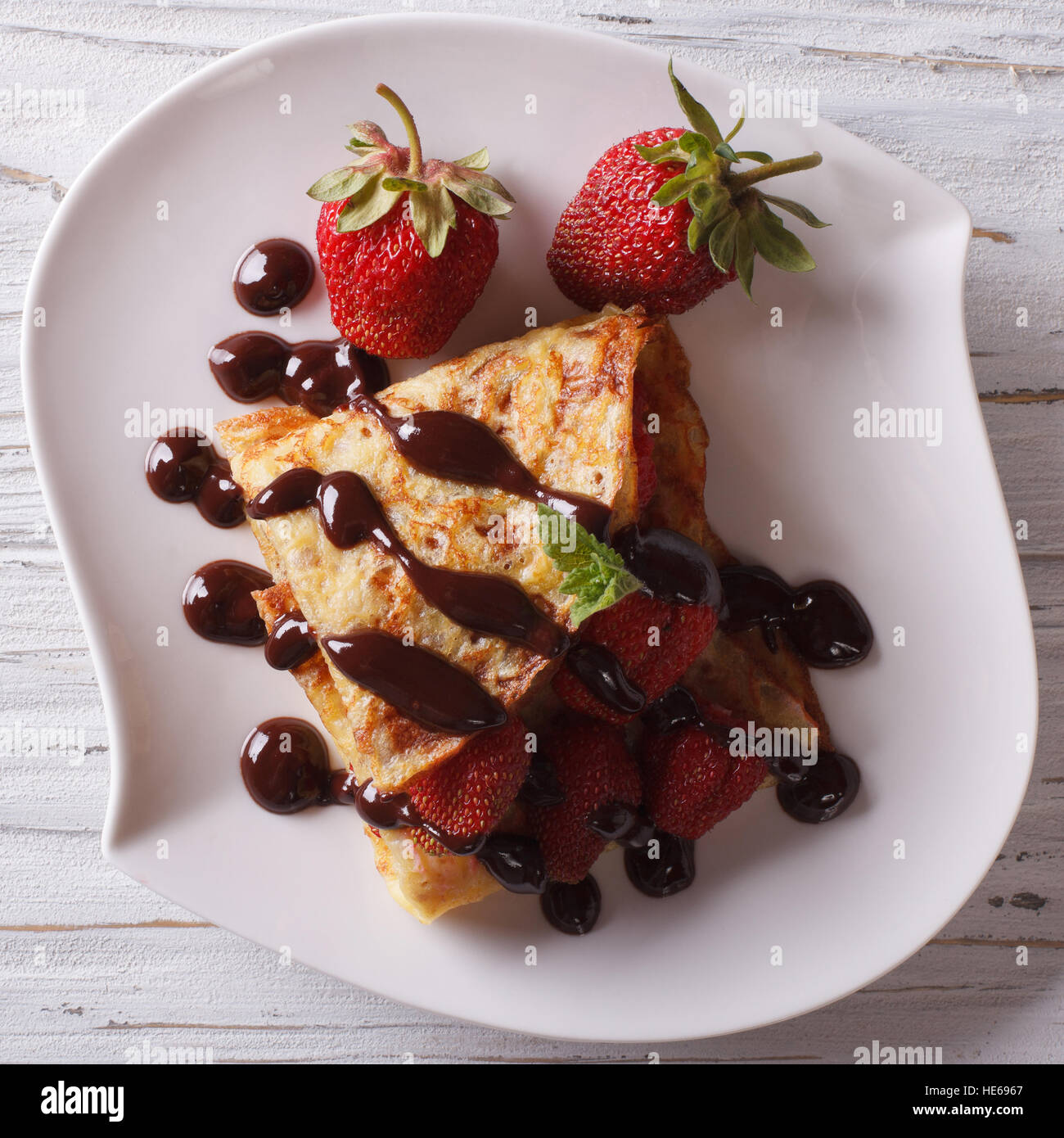 crepes with strawberries and chocolate close-up on the table. top view ...