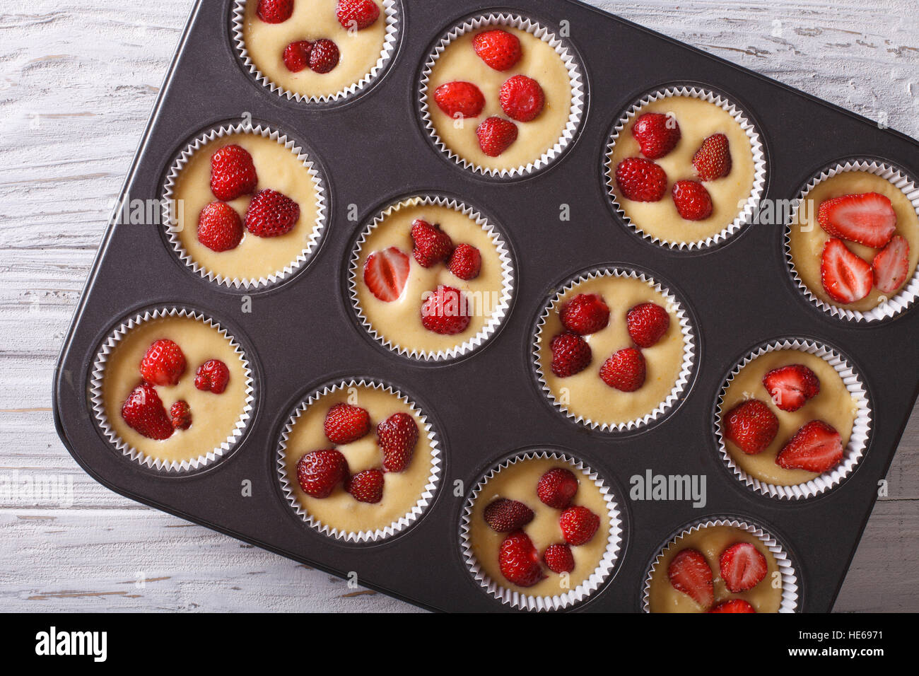 Preparation strawberry muffins in baking dish closeup. horizontal view ...