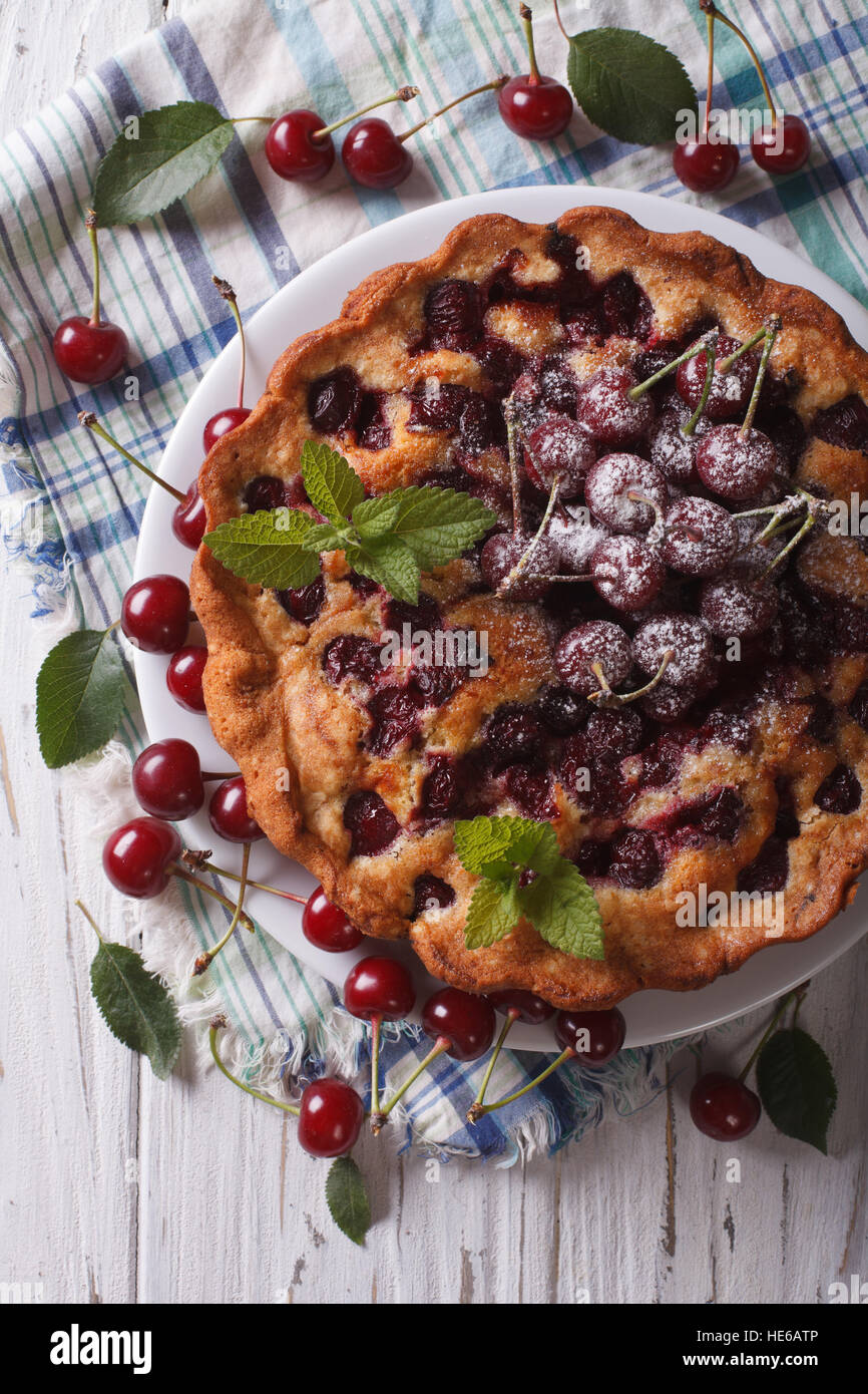 Rustic whole cherry pie close up on a plate on the table. vertical top ...