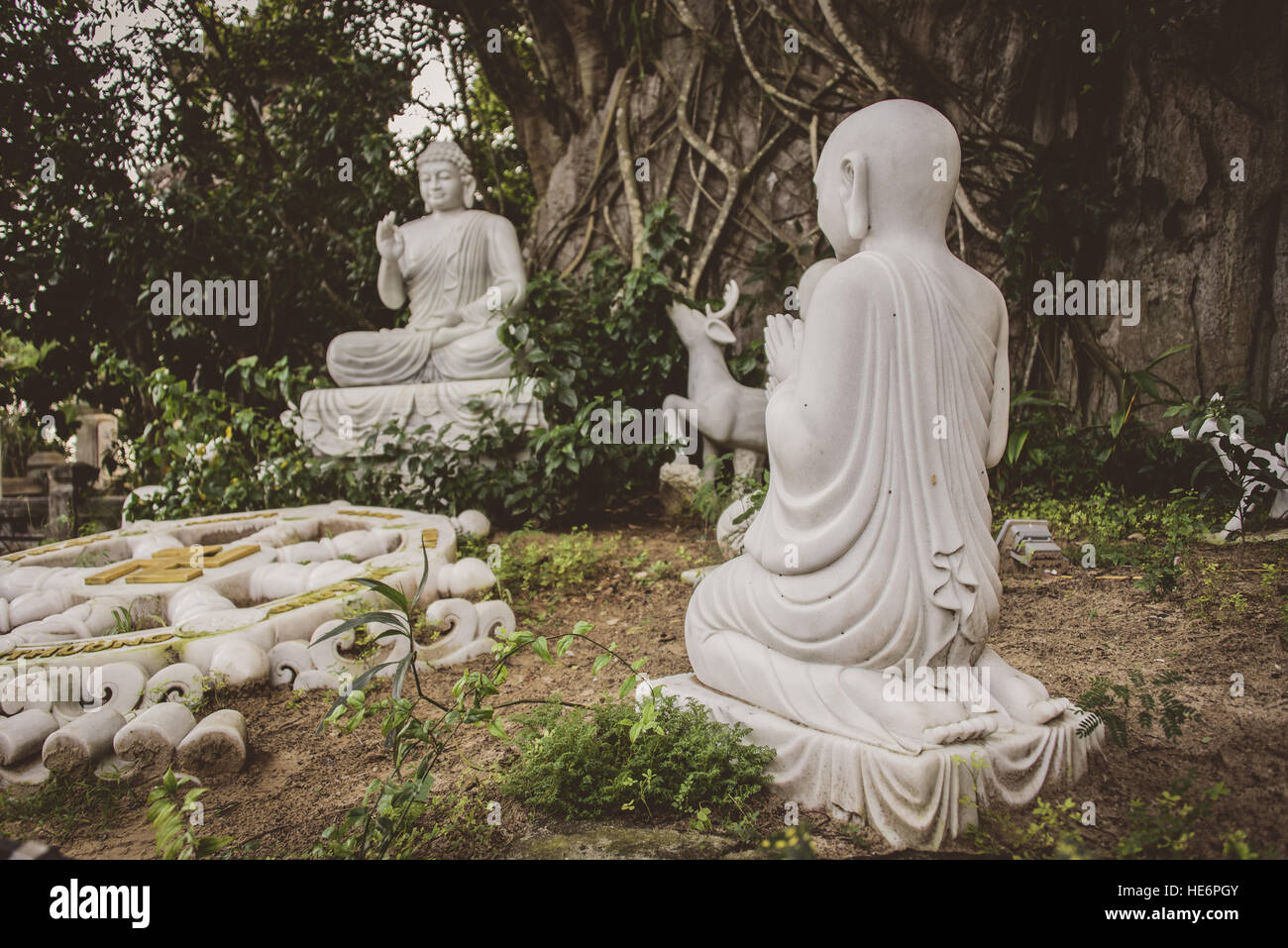 Buddha statues in Marble surrounding a dharmacakra wheel with swastika ...