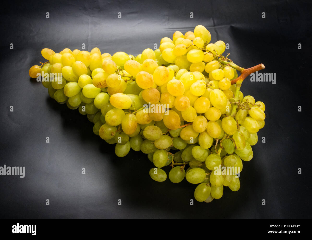 Large grapes cluster amber color on black background Stock Photo - Alamy