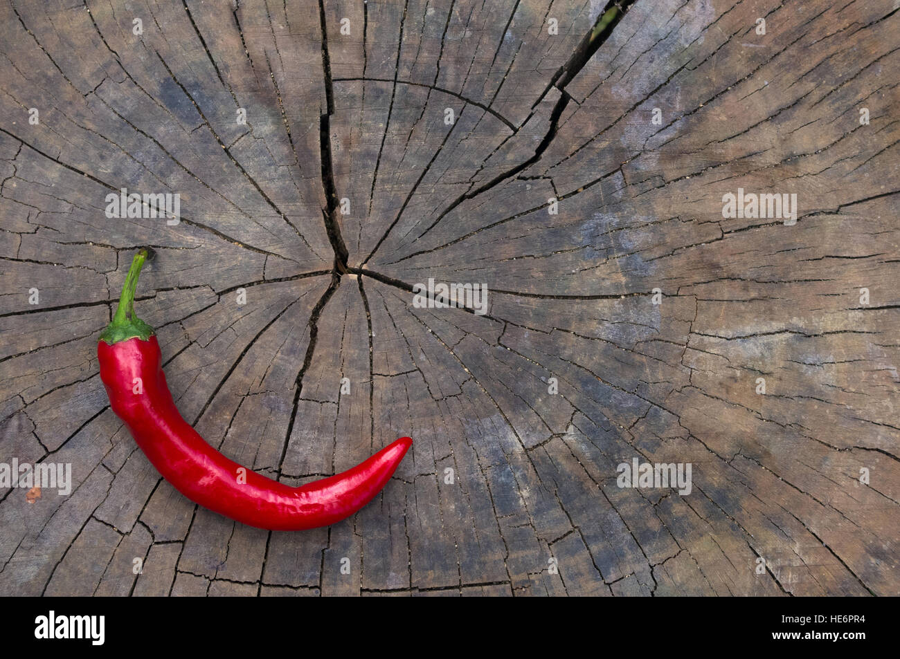 A pod of red hot chili peppers on the old worn wooden background Stock ...