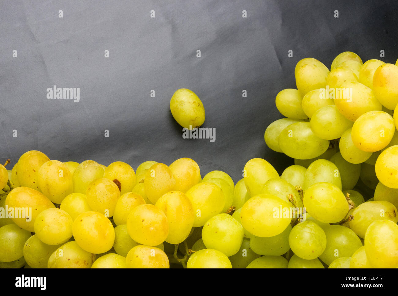 Large grapes cluster amber color on black background Stock Photo - Alamy