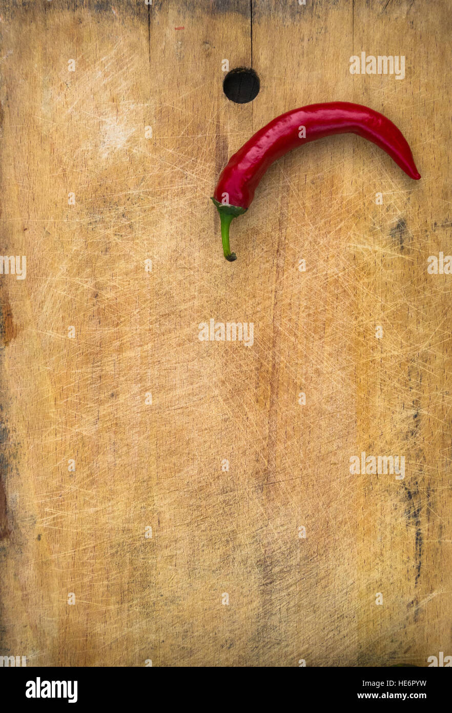 A pod of red hot chili peppers on the old worn wooden background Stock ...