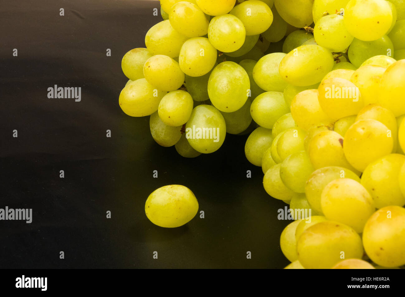 Large grapes cluster amber color on black background Stock Photo - Alamy